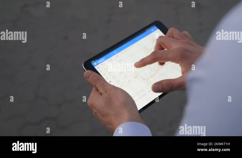 Man hands holding tablet using touch screen graphs charts working ...