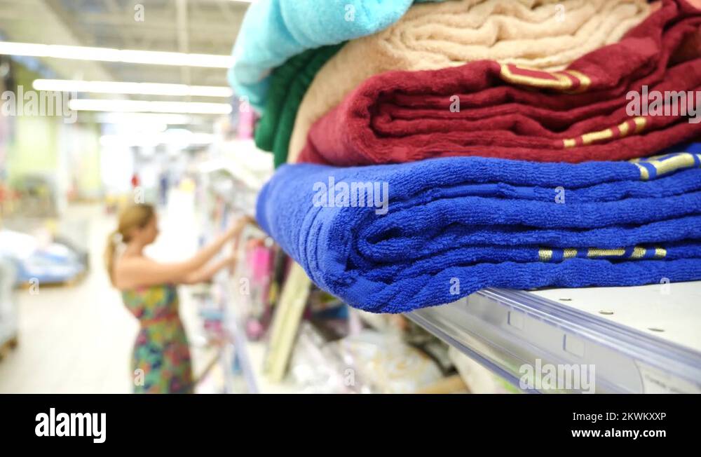 Young girl choosing bath towels textile in apparel clothes shop ...