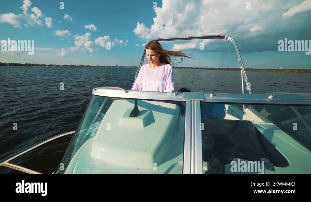 A woman is driving a boat. Hair in the wind, emotions. Sunny weather, a ...