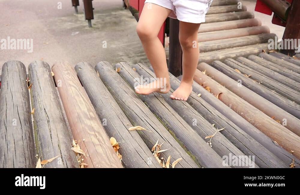 Barefoot legs kid girl play on park playground for children enjoy be ...