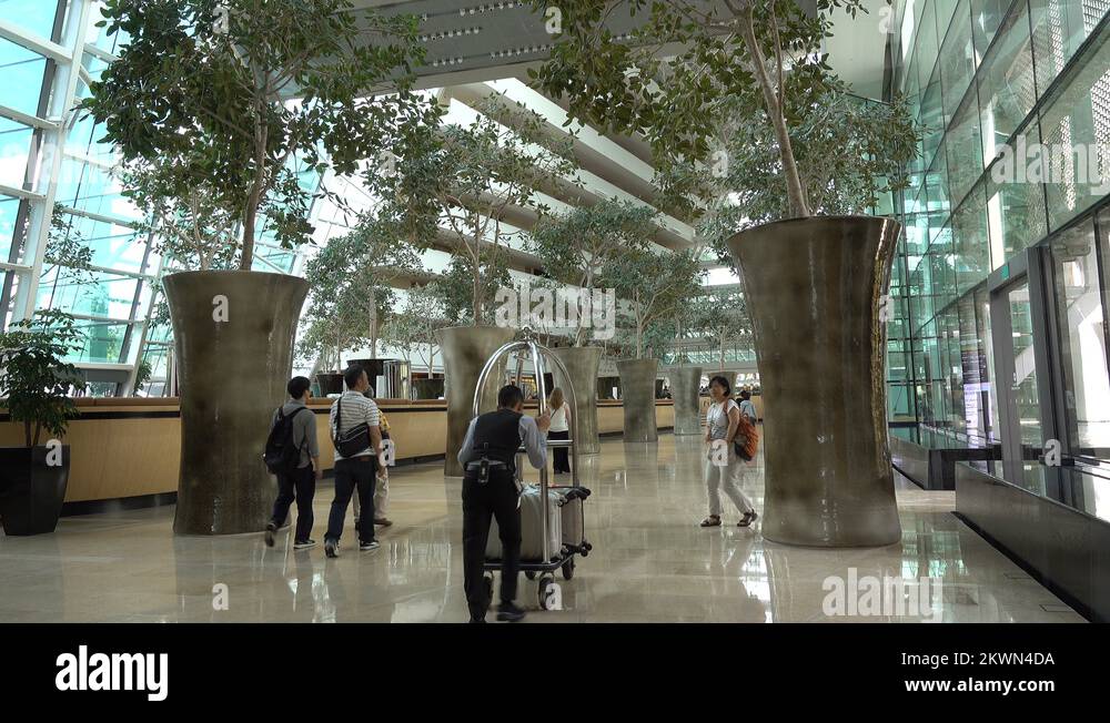 Hotel guests walk through modern lobby Marina Sands Bay resort ...