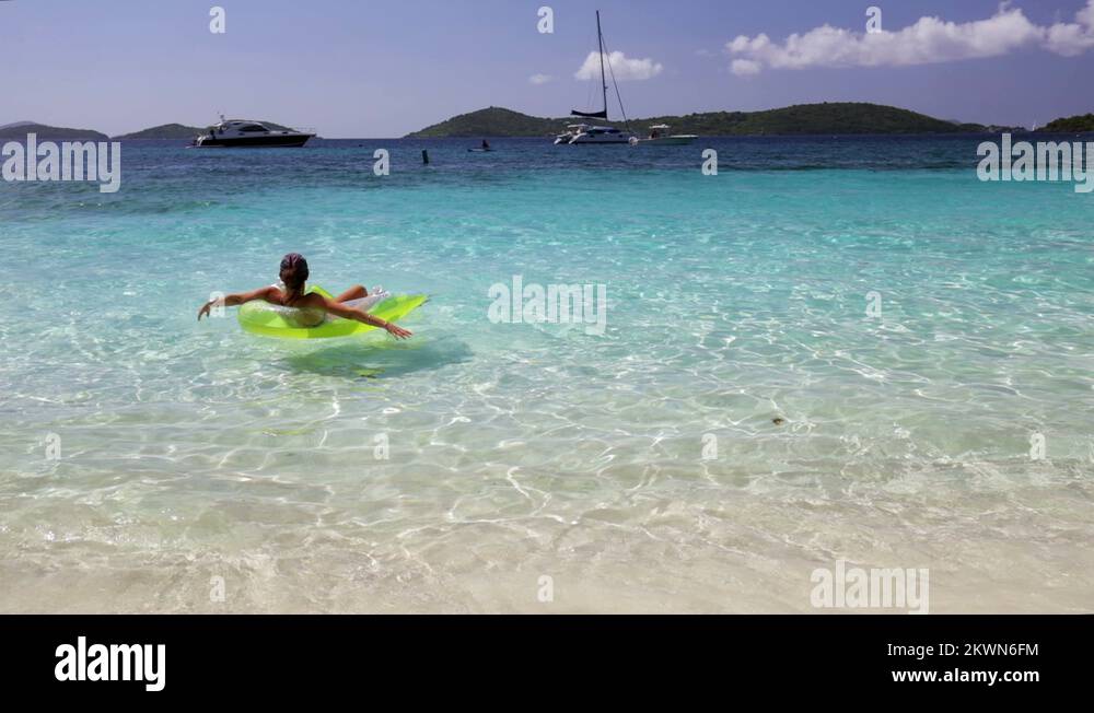 woman relaxing in raft on tropical beach, honeymoon beach, st john ...