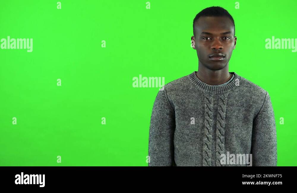A young black man shakes his head at the camera - green screen studio ...