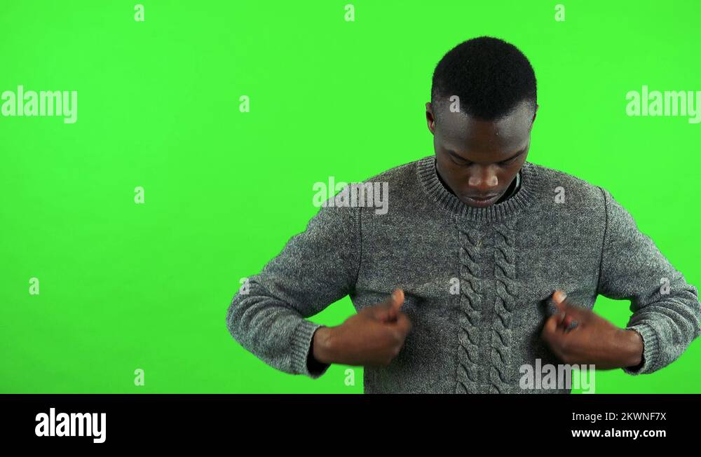 A young black man adjusts his clothes and smiles at the camera - green ...