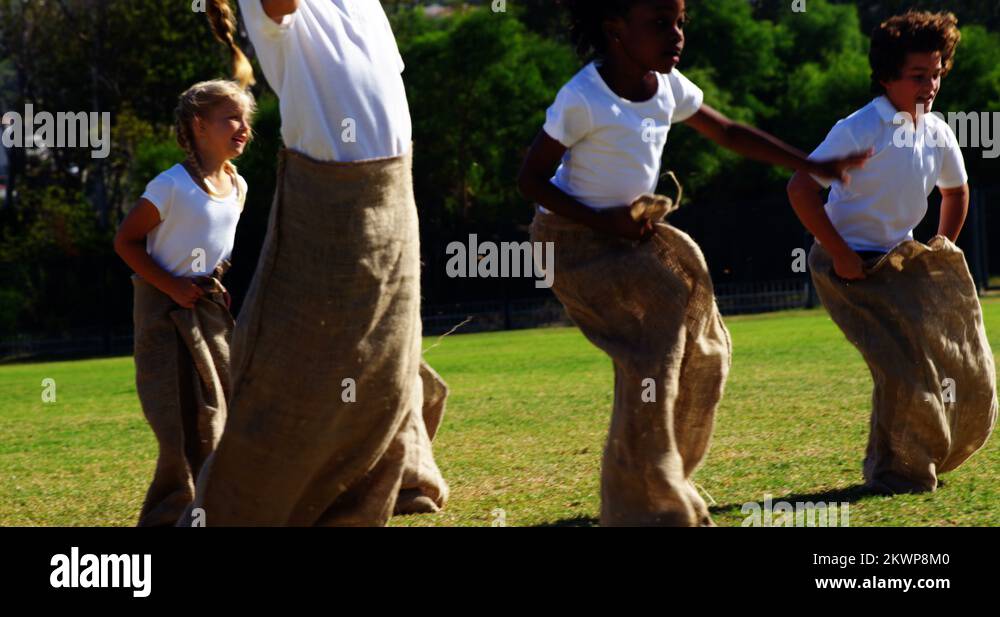 Children playing a sack race in park Stock Video Footage - Alamy