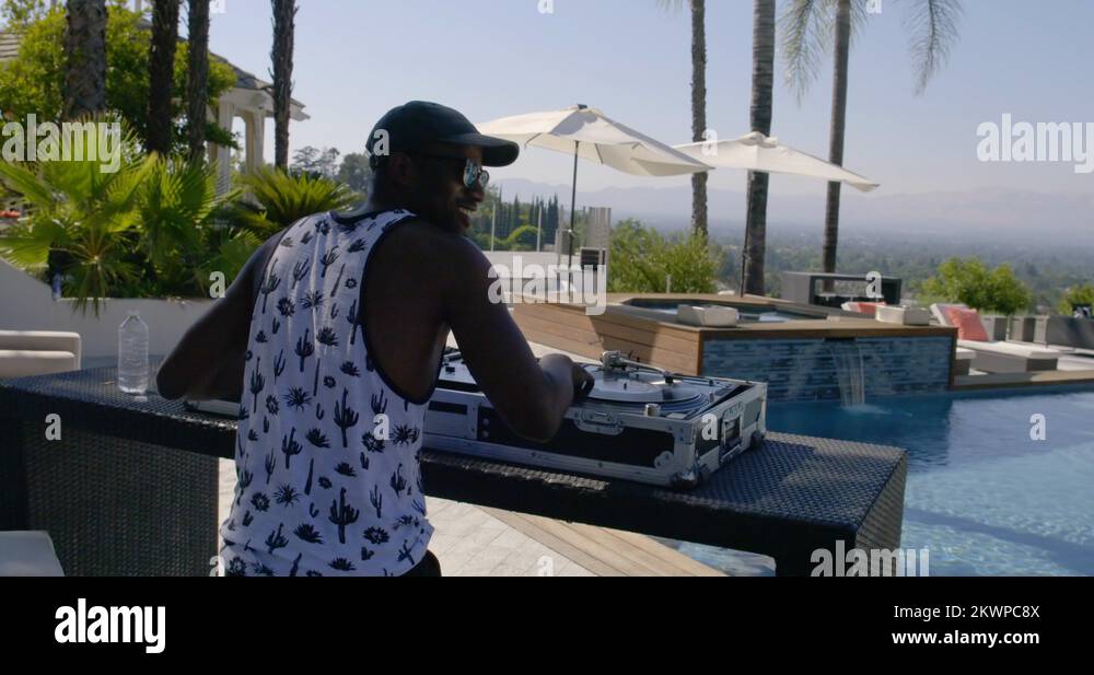 Dark skinned DJ setting up decks for tropical pool party 4K Stock Video ...