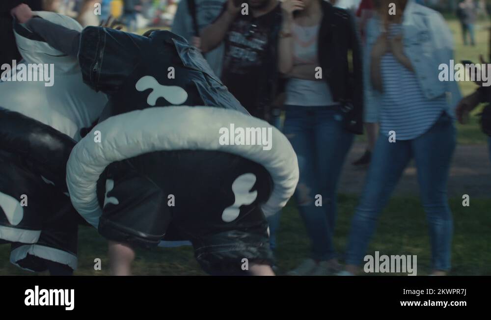 Teenage boys in big sumo costumes wrestling on ring at summer festival ...