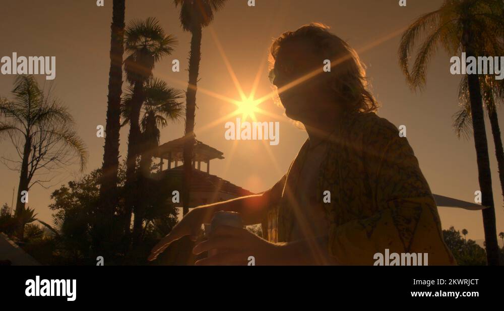 Silhouetted man in beach wear backlit by golden sun in slow motion 4K ...