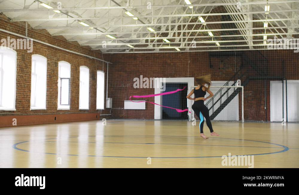 Attractive female gymnast jumping with ribbon Stock Video Footage - Alamy