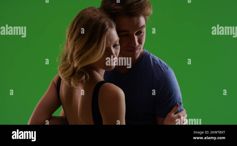 Romantic couple embracing with faces pressed together on green screen ...