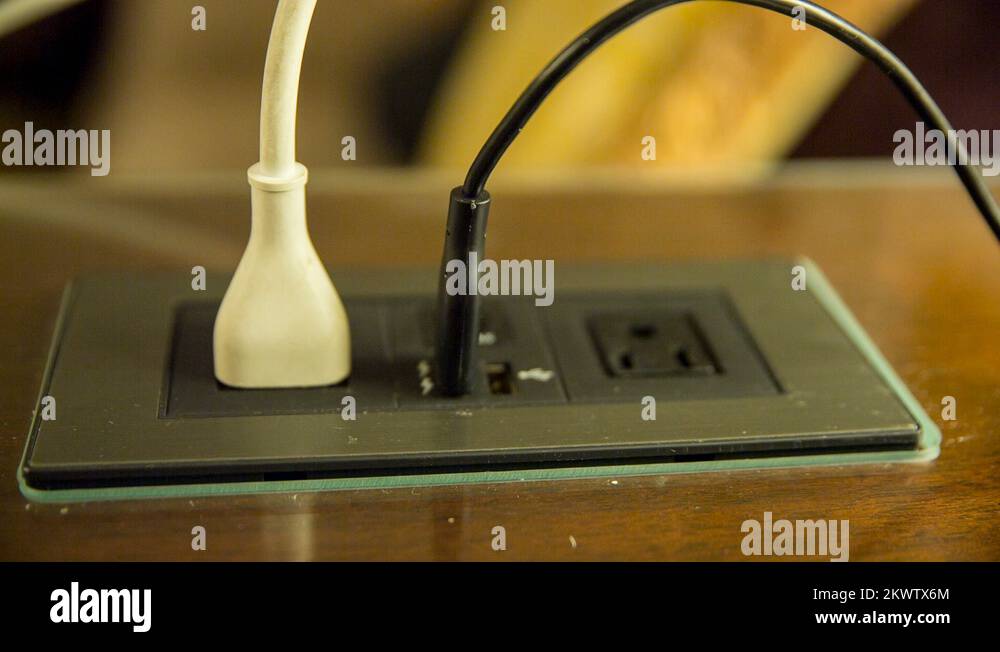 Female Plugs in Cord to Desk Power Console Stock Video Footage - Alamy