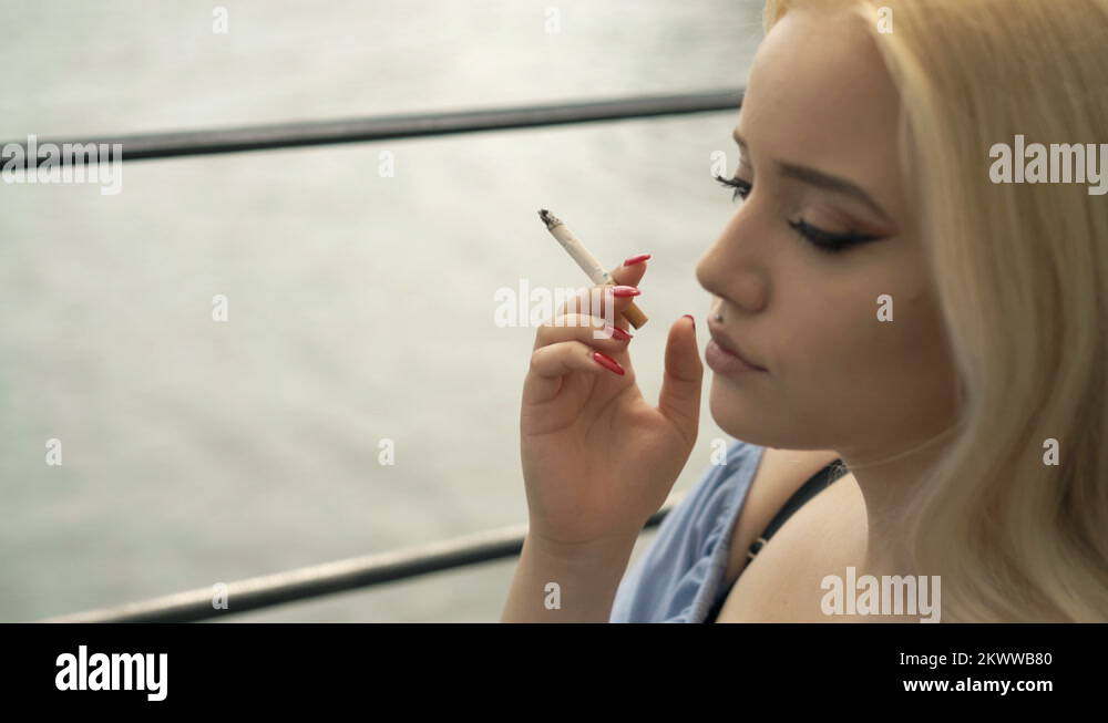 Young, teenage girl smoking cigarette by river Stock Video Footage - Alamy