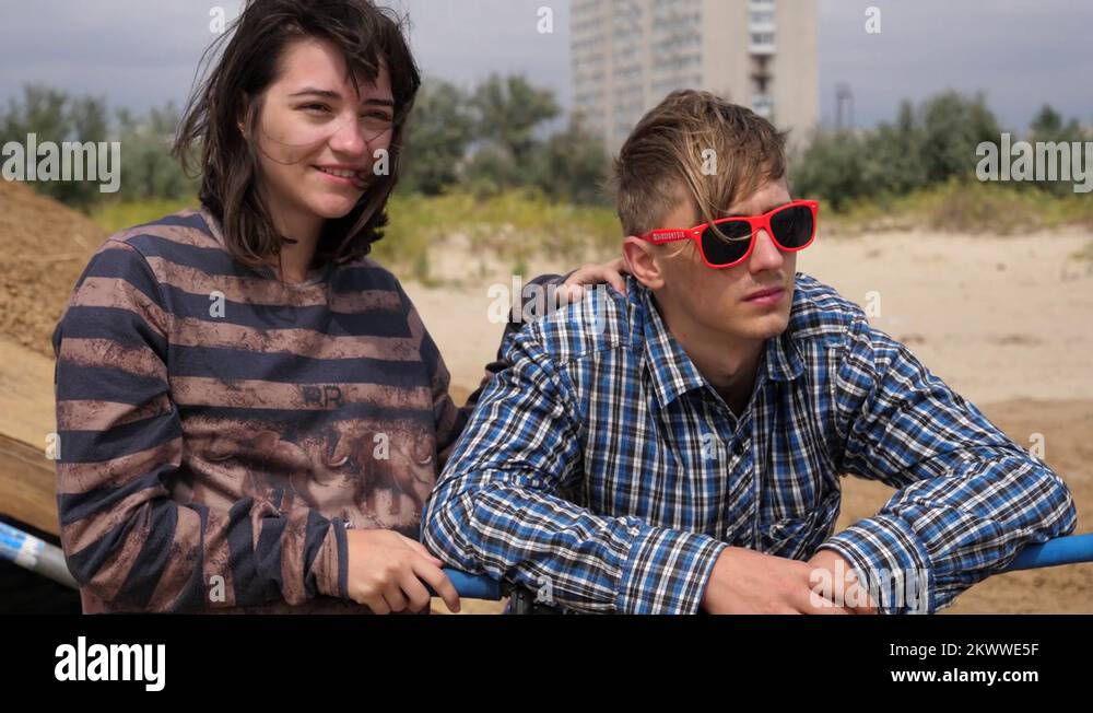 Young people couple on a beach at cool wind weather sit and rest Stock ...