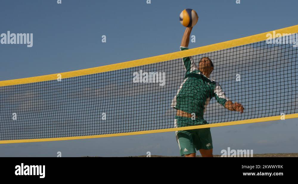 A Beach Volleyball player tips the ball over the net Stock Video ...