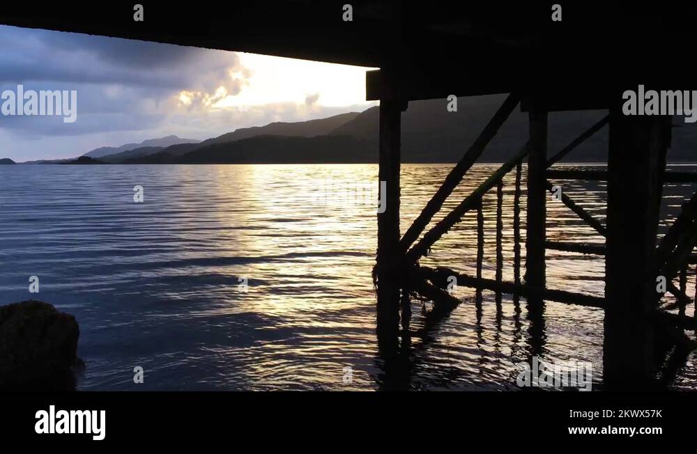 Waters flow and ripple underneath the wooden dock of Loch Sunart 4K as ...