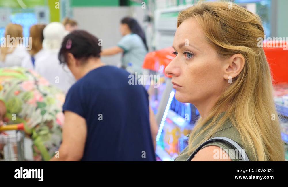 The queue of people standing at the checkout in the supermarket. 4k ...