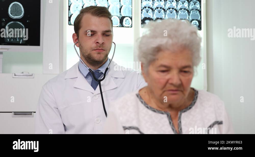 Pneumologist Doctor Man Using Stethoscope Examines Lungs of Old Lady in ...
