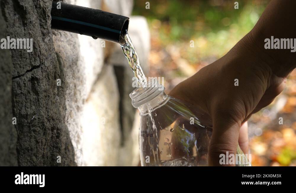 Draw drinking clear pure mountain sourse water in a plastic bottle ...