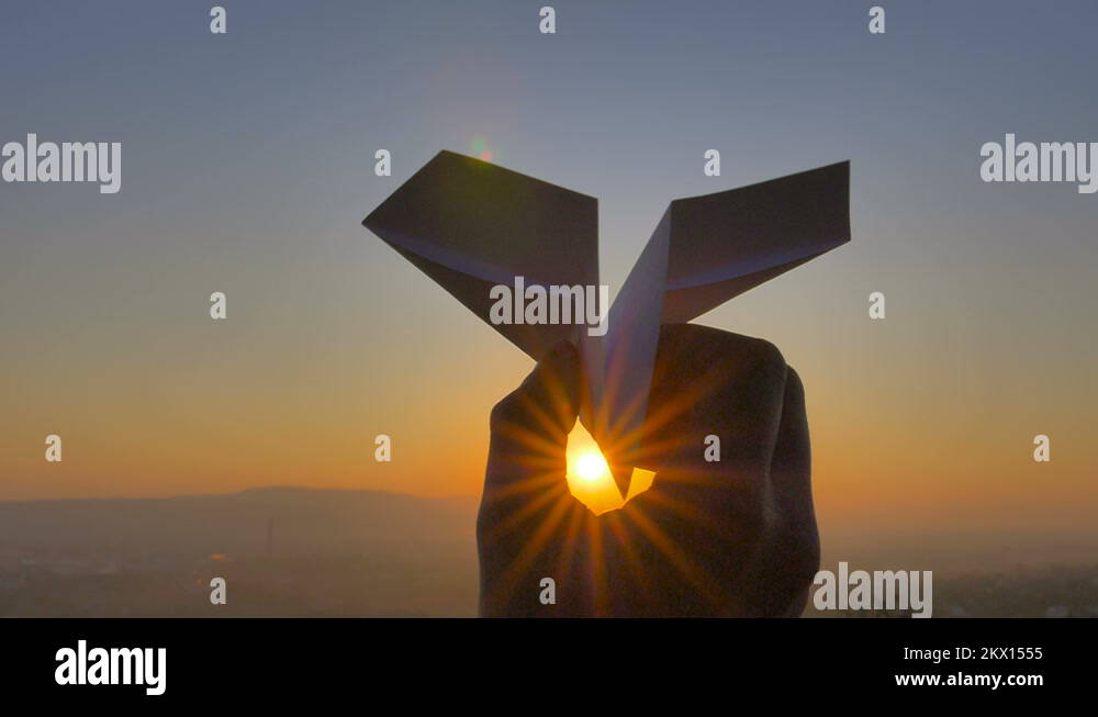 The hand launch paper airplane on sunset background. slow motion ...