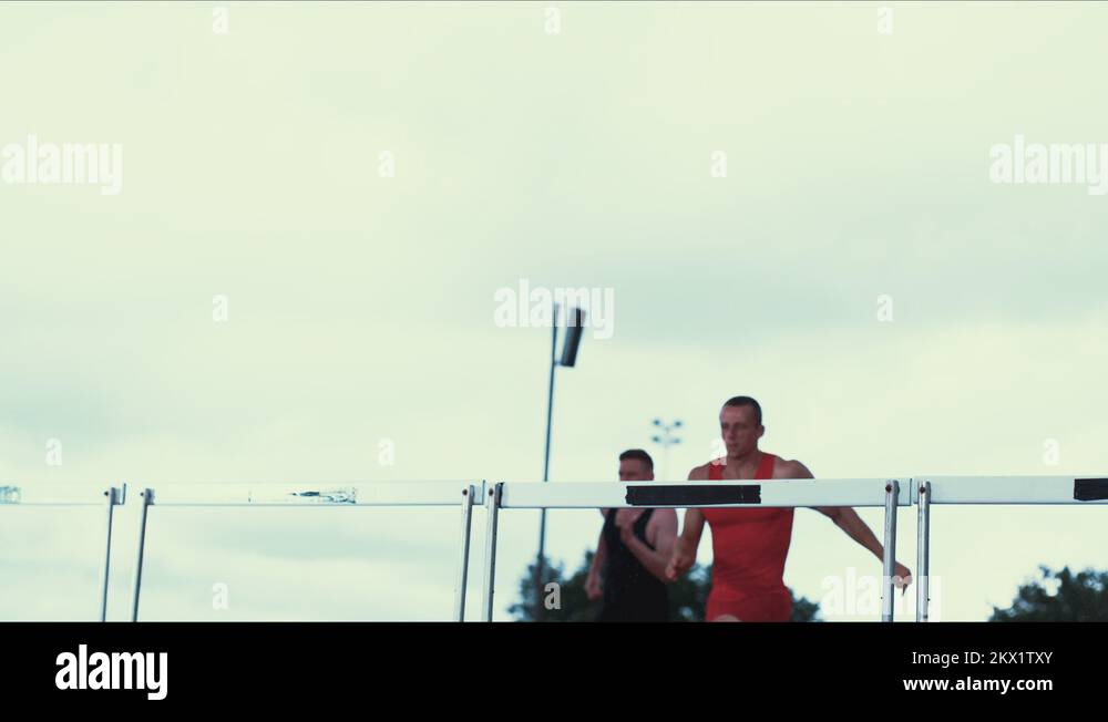 Male hurdle athletes training on running track, shot on Phantom Flex at ...
