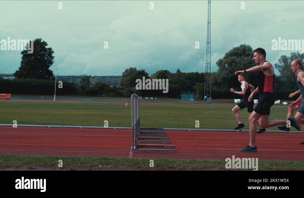 Male hurdle athletes training on running track, shot on Phantom Flex at ...