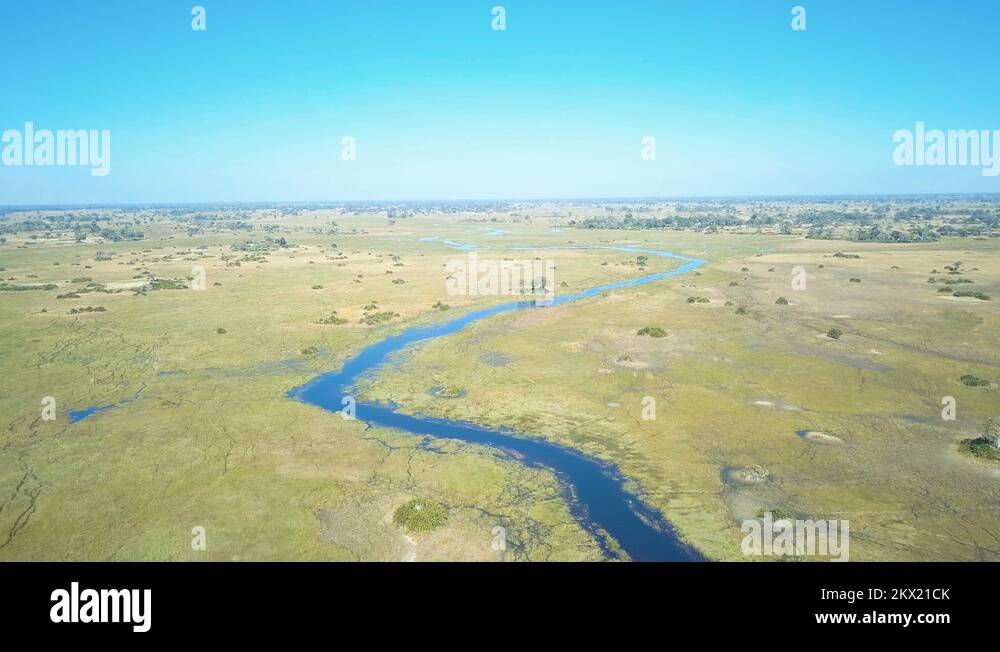Shallow river in flood plain with animal tracks on its sides Okavango ...