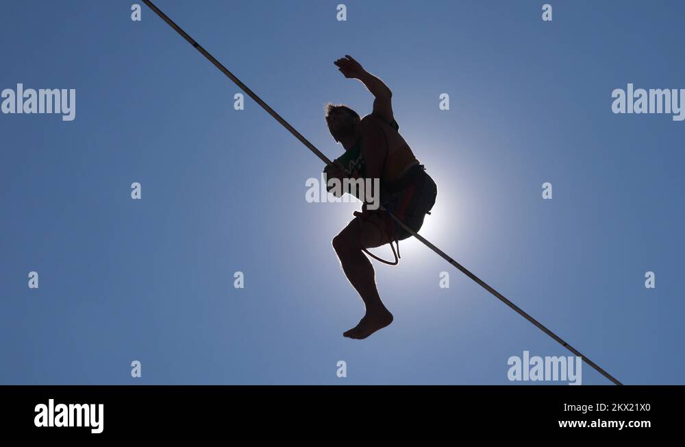 Acrobat circus young man silhouette walking balancing on tight rope in ...
