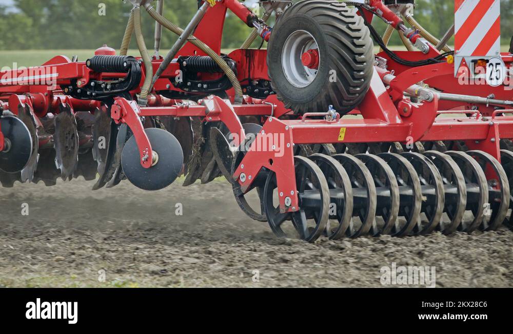 Sowing machine working on farming field. Farming tractor with trailer ...