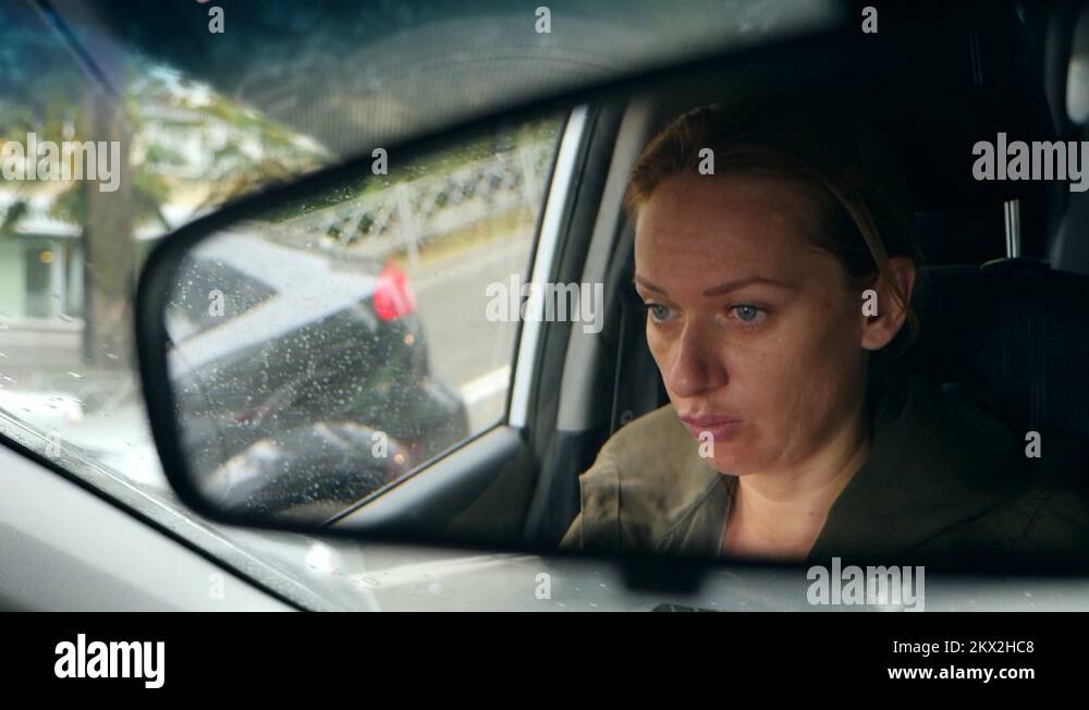 Reflection of a woman's face with blue eyes in rearview mirror, woman ...