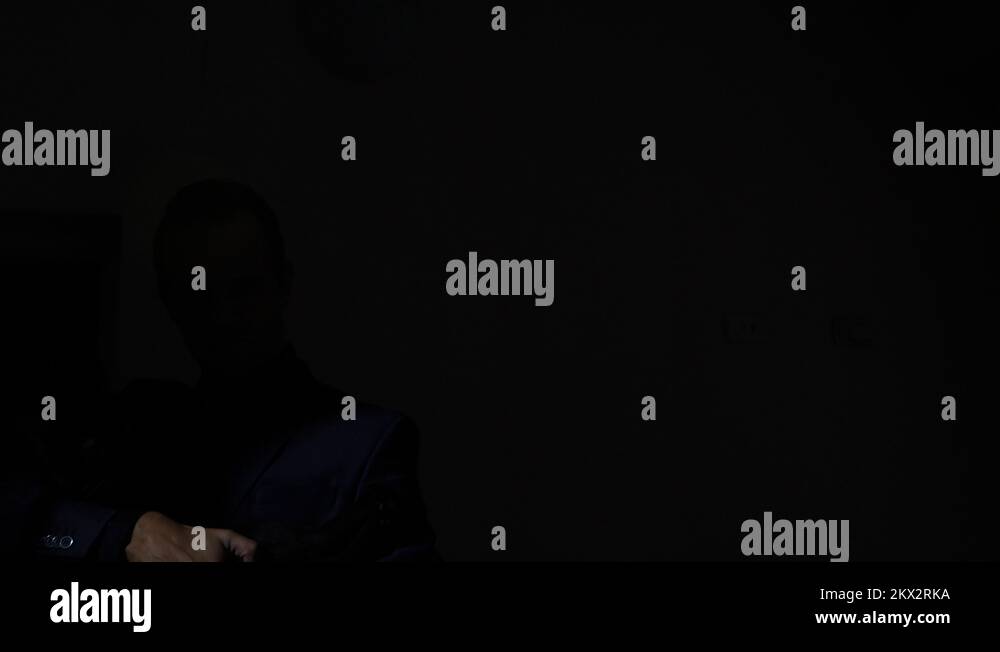 Man pulling out his gun in the darkness and aiming at the camera. 4k ...