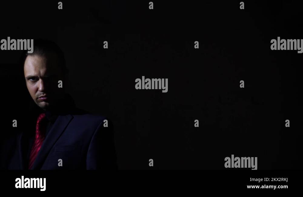 Man pulling out his gun in the darkness and aiming at the camera. 4k ...