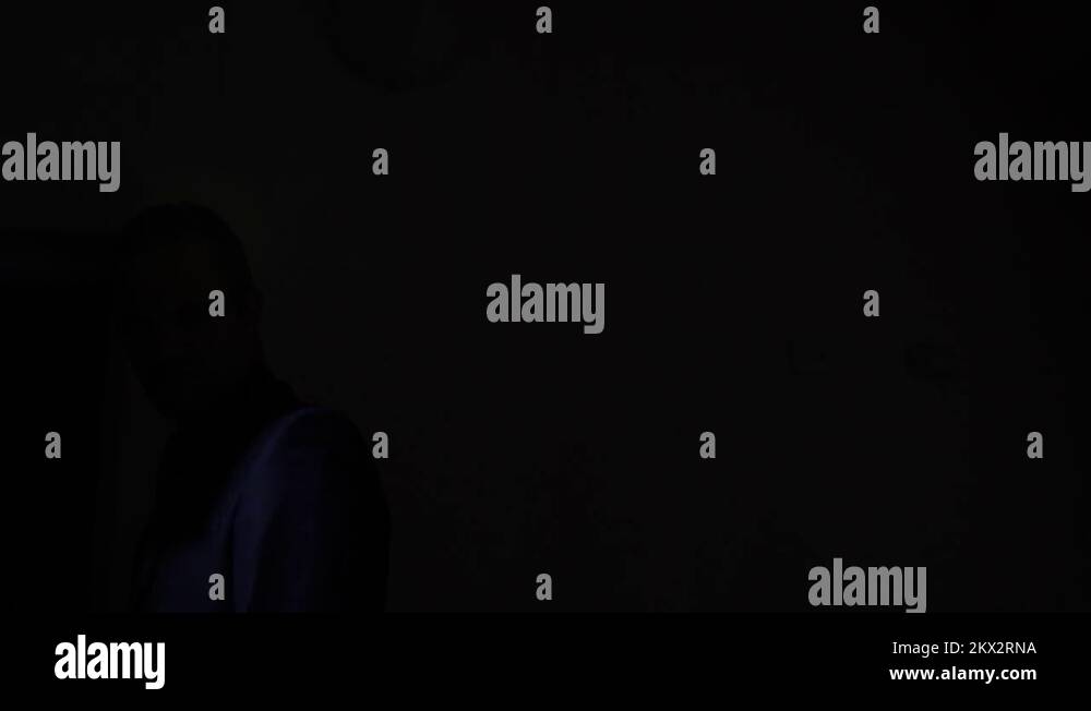 Man pulling out his gun in the darkness and aiming at the camera. 4k ...