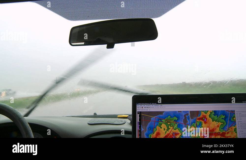 Inside a storm chaser's van on a rainy road, close view of weather map ...
