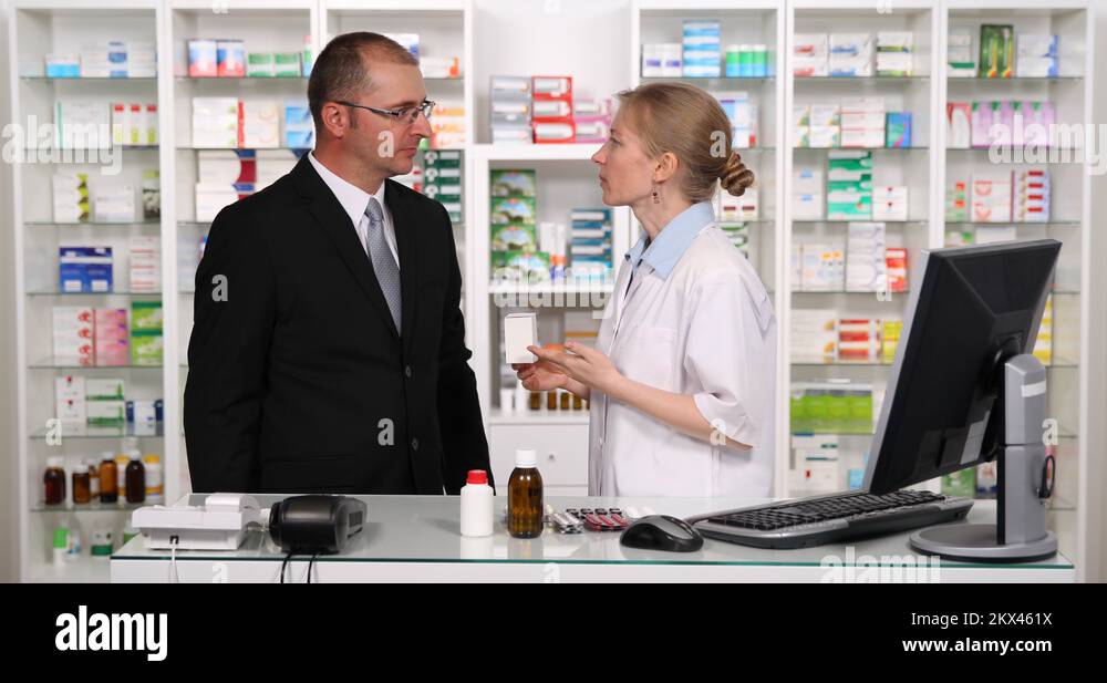 Young Druggist Man Helping Patient Lady to Buy Drugs with Prescription ...