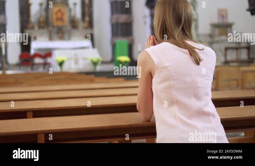 Young devoted religious woman praying in catholic church. Faithful ...