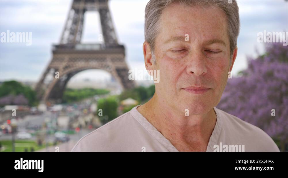 Stern white male looks coldly at camera near Eiffel Tower Stock Video ...