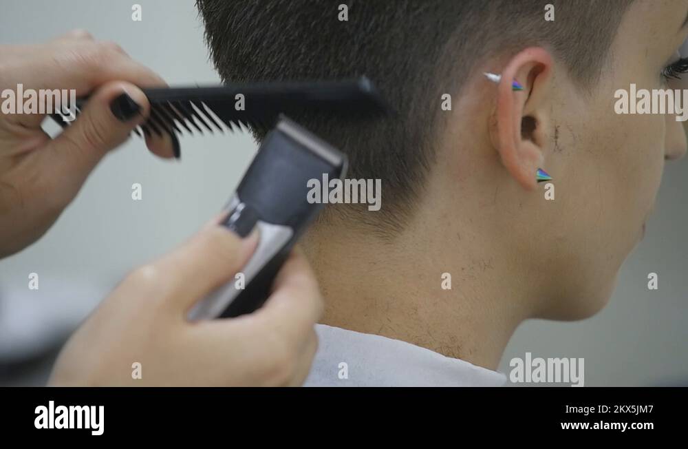Haircut at barber's. Female hairdresser shaping women's hair into a ...