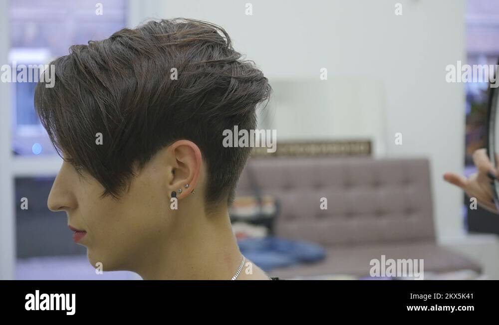 Professional hairdresser shows the back view of the haircut using ...