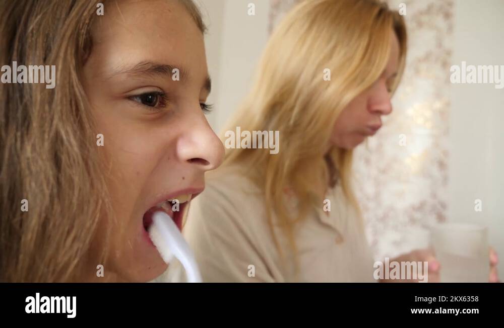 Mother and daughter at home brushing teeth in mirror. 4k, slow motion Stock Video Footage - Alamy
