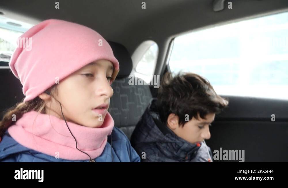4k, slow motion. brother and sister twins, ride in the back seat of the ...