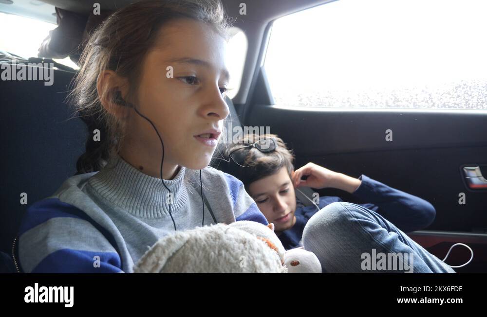 4k, slow motion. brother and sister twins, ride in the back seat of the ...