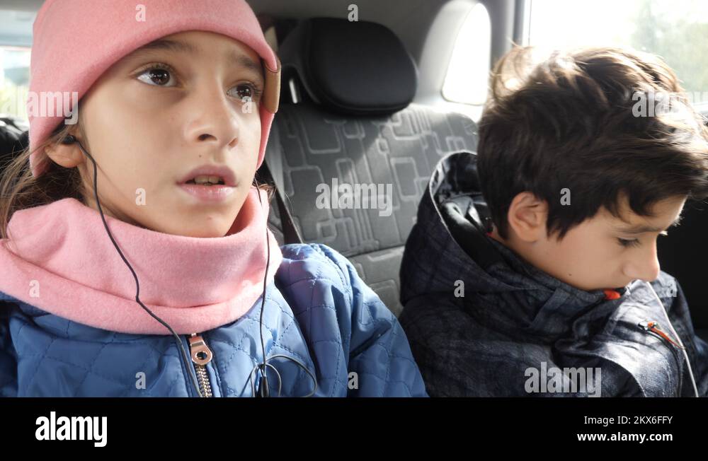 4k, slow motion. brother and sister twins, ride in the back seat of the ...