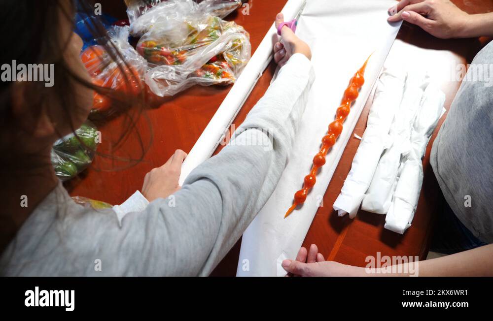 Mom and her daughter collect a parcel with oriental sweets and fruits ...