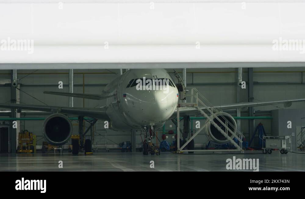 Roller shutter door and plane in hangar background. Business jet ...