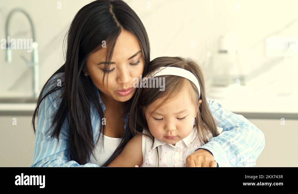 Young mom using cosmetics with her daughter at home Stock Video Footage ...