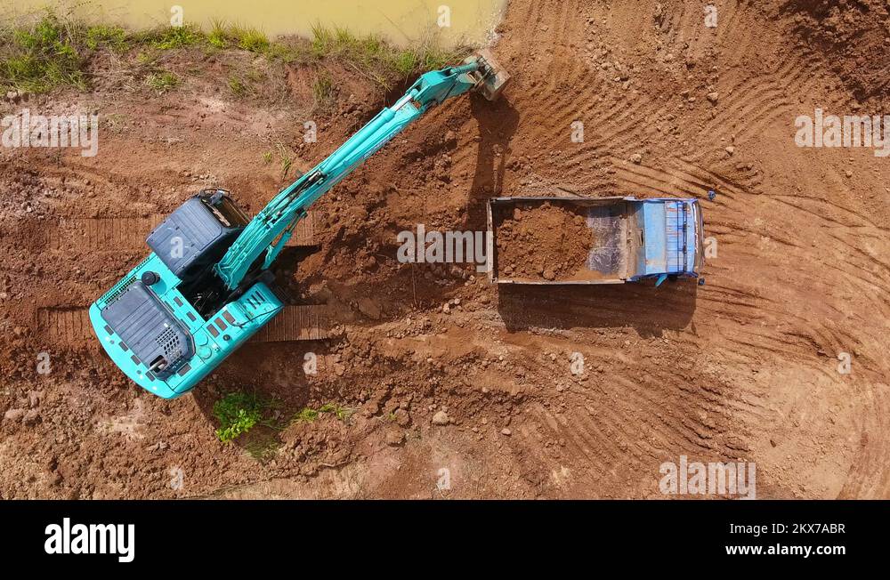 Backhoe and truck working construction site in thailand. Aerial view ...