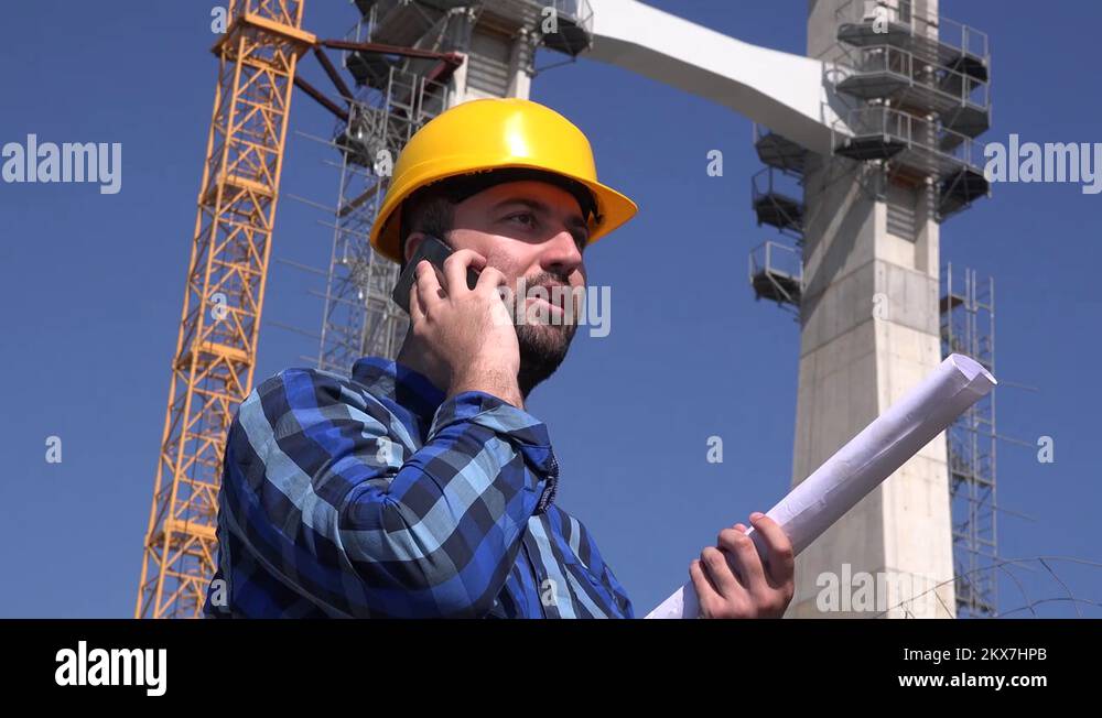 Successful handsome architect supervisor with blueprints cell phone ...