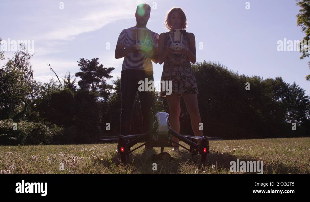 Man and Woman Starting Up Drone In Slow Motion Silhouette Sun Flare ...