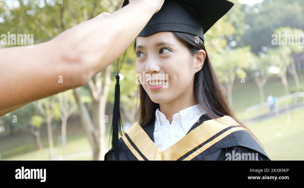 Father help her daughter adjust the mortarboard in graduation day Stock ...