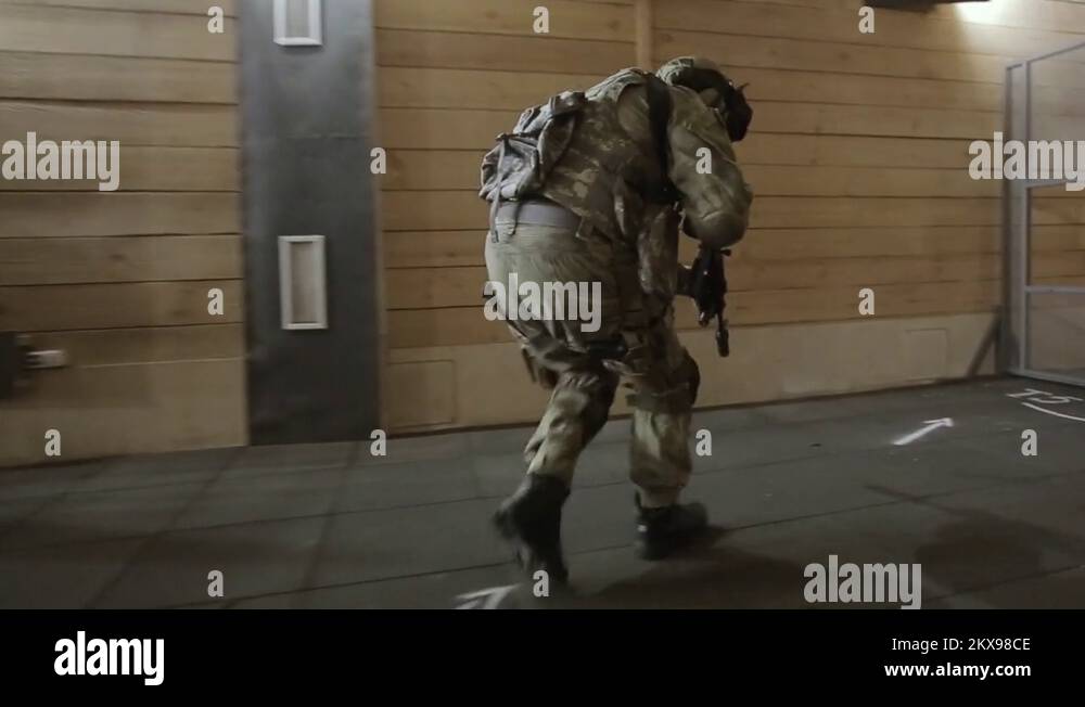 Special forces soldier in full gear firing automatic weapons running to ...